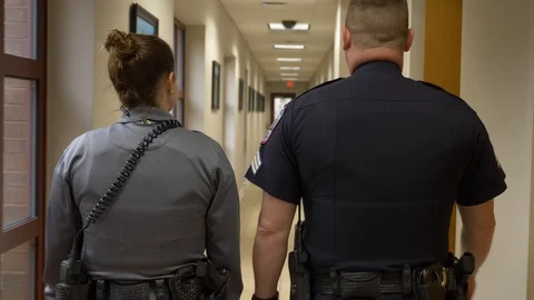 Police officers walk down station hallwa... | Stock Video | Pond5