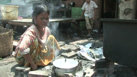 Poor woman cooks over fire in a slum of ... | Stock Video | Pond5