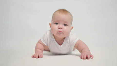 Portrait of a contented baby on a white ... | Stock Video | Pond5