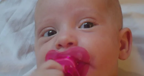 Portrait of a cute baby with a pink paci... | Stock Video | Pond5