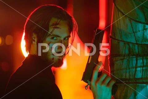Portrait of a handsome wounded special agent standing on alert with a ...