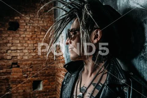 Photograph: A portrait of a stylish punk man in the street. Modern men ...