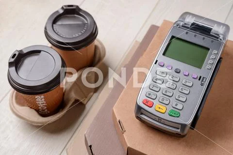 Photograph: POS terminal, coffee paper cups and pizza boxes #123569382