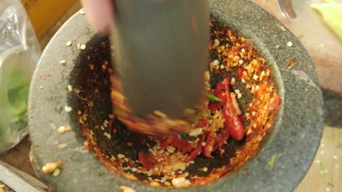 Pounding garlic and chilli in stone mort... | Stock Video | Pond5