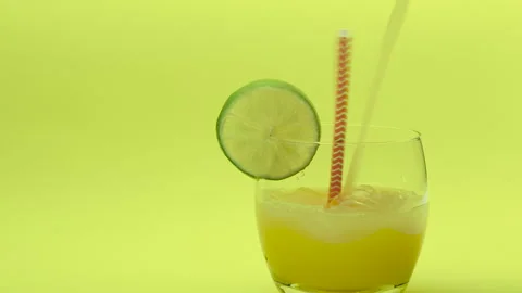 Pour fruit drink into a glass on a yello... | Stock Video | Pond5