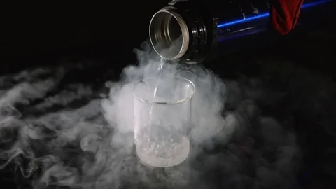 Pour liquid nitrogen from thermos into b... | Stock Video | Pond5