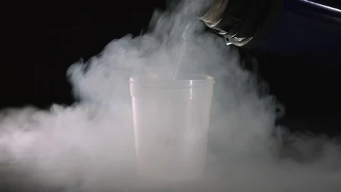Pouring liquid nitrogen in plastic glass | Stock Video | Pond5