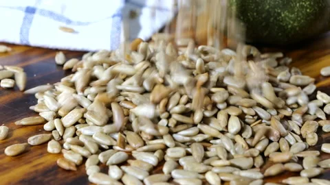 Pouring sunflower seeds into a mound on ... | Stock Video | Pond5