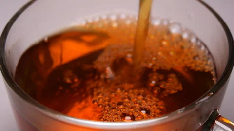 Pouring tea into the cup and stir sugar | Stock Video | Pond5