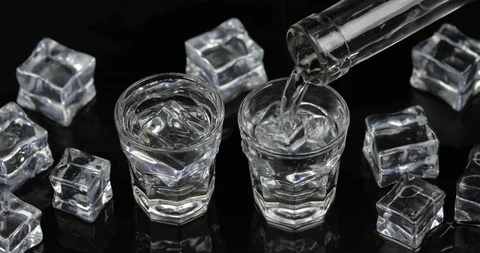 Pouring up two shots of vodka from a bot... | Stock Video | Pond5