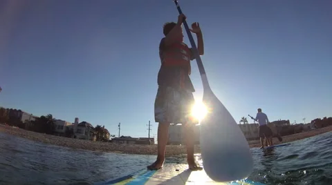POV of a boy falling off an SUP stand-up... | Stock Video | Pond5