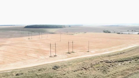 Power lines on field. High voltage pylon... | Stock Video | Pond5