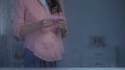 Pregnant female putting pink baby socks ... | Stock Video | Pond5