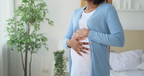 Pregnant woman caressing her belly at ho... | Stock Video | Pond5