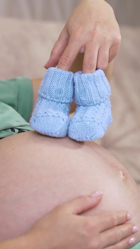 Pregnant woman holding knitted socks on ... | Stock Video | Pond5