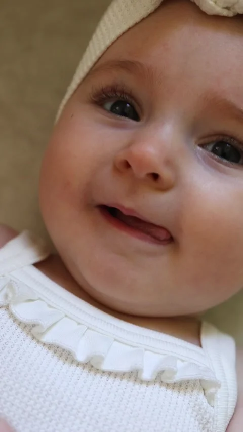 pretty baby girl bit her tongue and look... | Stock Video | Pond5