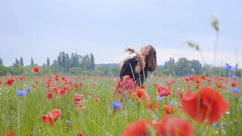 Pretty girl dancing in a poppy field smi... | Stock Video | Pond5