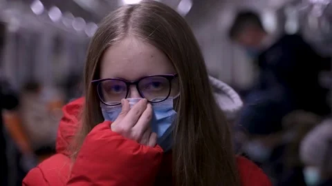 Pretty teen girl pulling up mask on face... | Stock Video | Pond5