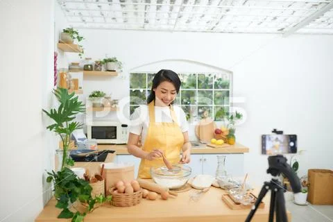 Photograph: Pretty young asian female food blogger working on a new ...