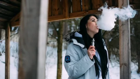 Pretty young girl vaping outside in good... | Stock Video | Pond5