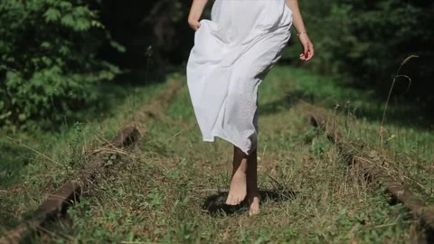 A pretty young girl walks barefoot on ti... | Stock Video | Pond5