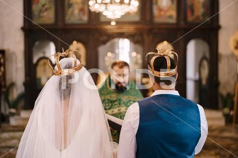 Priest marries the bride and groom in the church. Back view Stock Photo ...