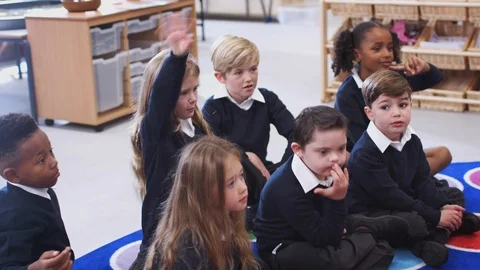 Primary school kids sitting on the floor... | Stock Video | Pond5