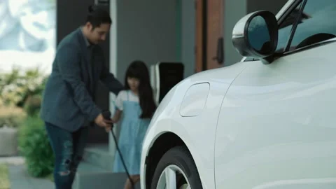 Progressive dad and daughter charging EV... | Stock Video | Pond5