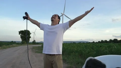 Progressive man with his EV car and wind... | Stock Video | Pond5