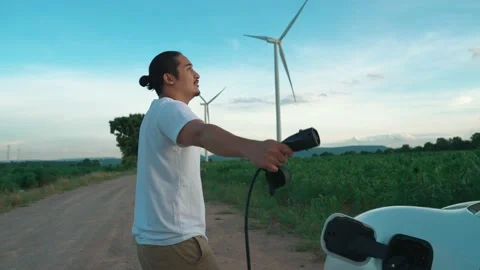 Progressive man with his EV car and wind... | Stock Video | Pond5