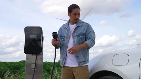Progressive man with his EV car and wind... | Stock Video | Pond5