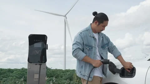 Progressive man with his EV car and wind... | Stock Video | Pond5