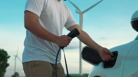 Progressive man with his EV car and wind... | Stock Video | Pond5