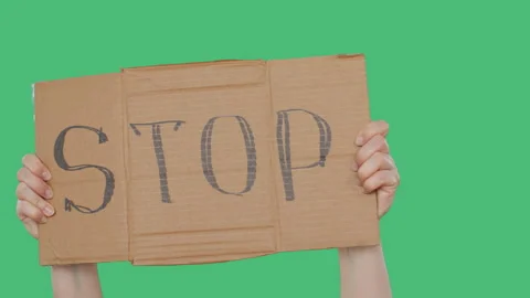 Protester holding stop cardboard sign in... | Stock Video | Pond5