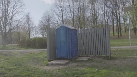 Public blue toilet surrounded by wooden ... | Stock Video | Pond5