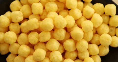 Puffed golden cheese balls rotating | Stock Video | Pond5