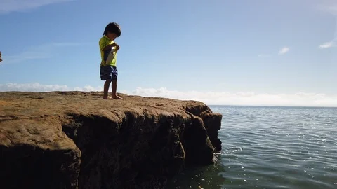 Pull away shot of young kid throwing roc... | Stock Video | Pond5