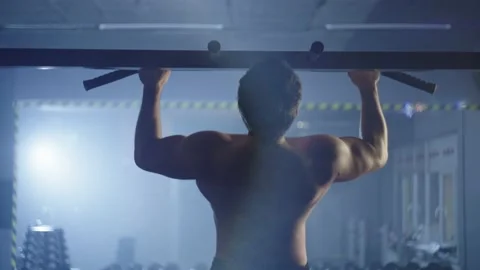 Pumped up young guy doing pull ups in th... | Stock Video | Pond5