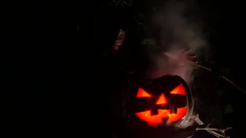 Pumpkin with red eyes in dark forest. Ha... | Stock Video | Pond5