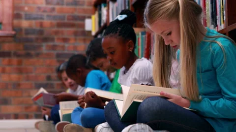 Pupils sitting in a row reading in the l... | Stock Video | Pond5