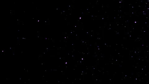 Purple sparkles floating in the air over... | Stock Video | Pond5
