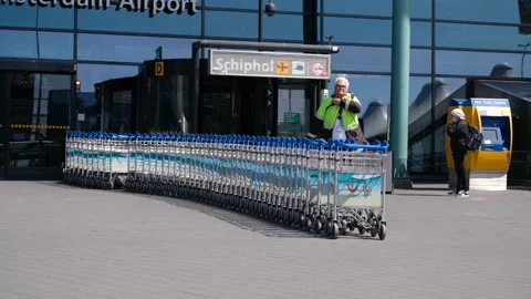 Push carts in front of Schiphol Airport | Stock Video | Pond5