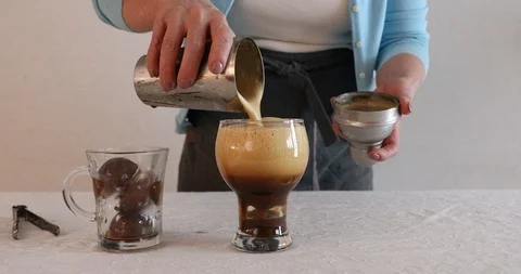 Putting ice in glass cup and pouring cof... | Stock Video | Pond5