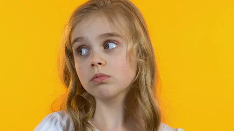 Puzzled little girl shrugging looking ar... | Stock Video | Pond5