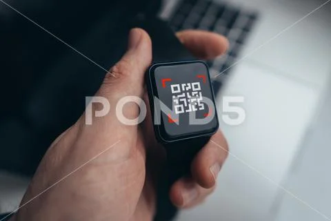 QR code concept. Clock with a symbol on the screen in the hands of the ...