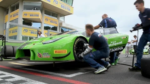 Racing car team at work on starting grid | Stock Video | Pond5