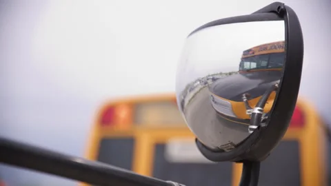 Rack focus from bus to mirror at school | Stock Video | Pond5