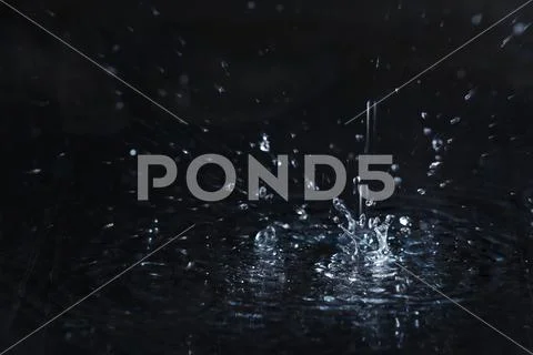Rain drop falling down into puddle on dark background ~ Premium Photo ...