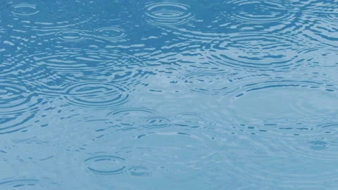 Rain drops falling making circle ripples... | Stock Video | Pond5