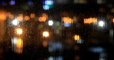 Rain Drops Falling on window with bokeh ... | Stock Video | Pond5